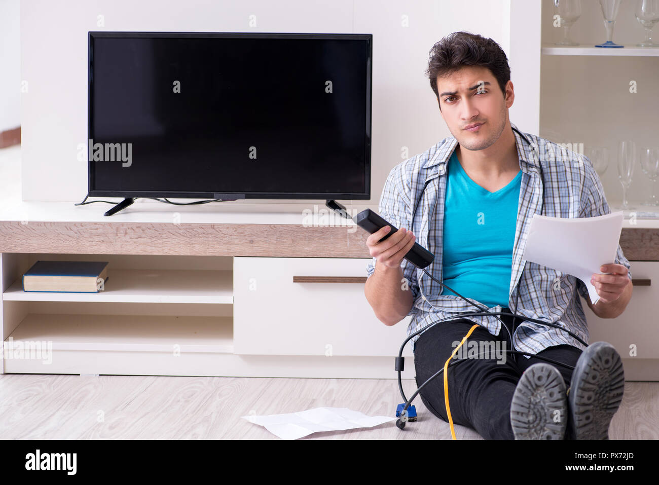 Man trying to fix broken tv Stock Photo - Alamy