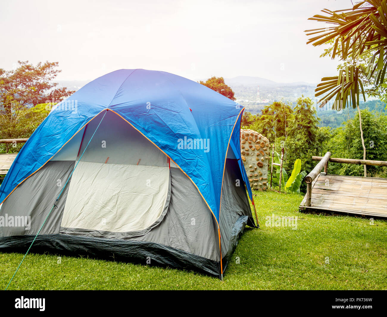 Camping blue tent on green grass with the mountain and blue sky view ...