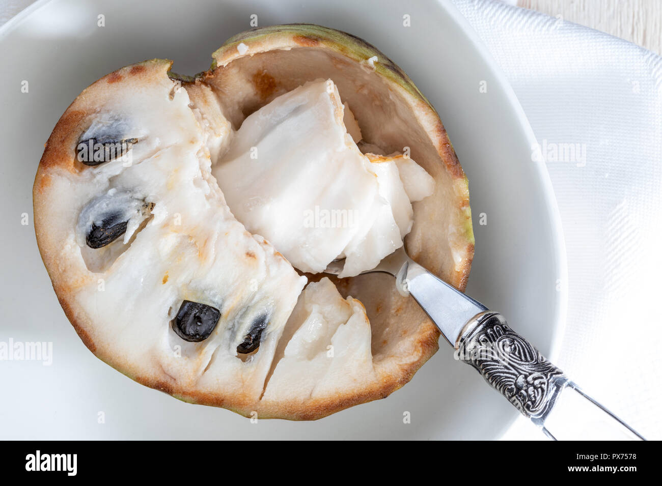 Close-up of ripe cherimoyas. Open fruit, with nuggets and spoon on ...