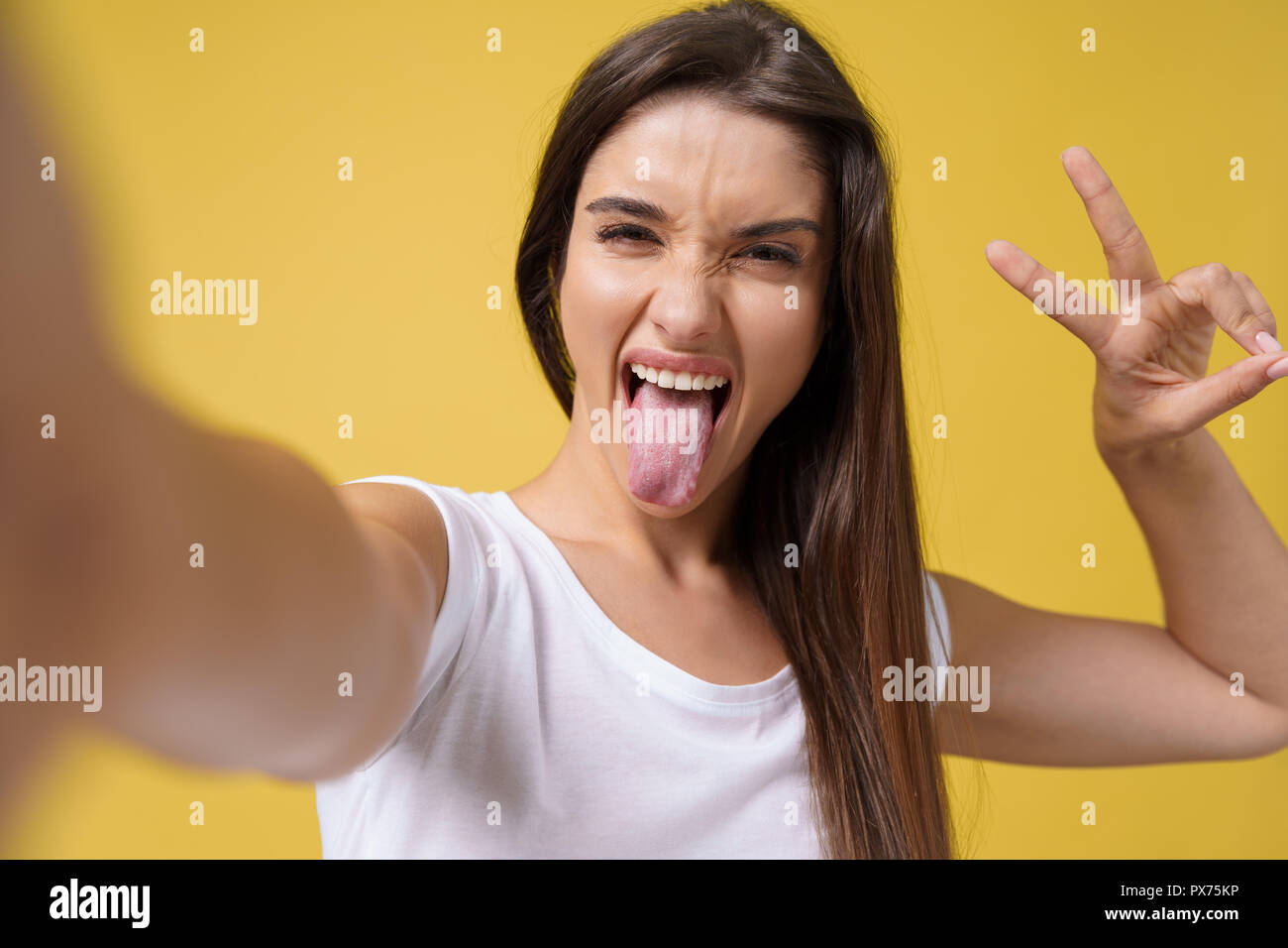 Pleasant attractive girl making selfie in studio and laughing. Good ...