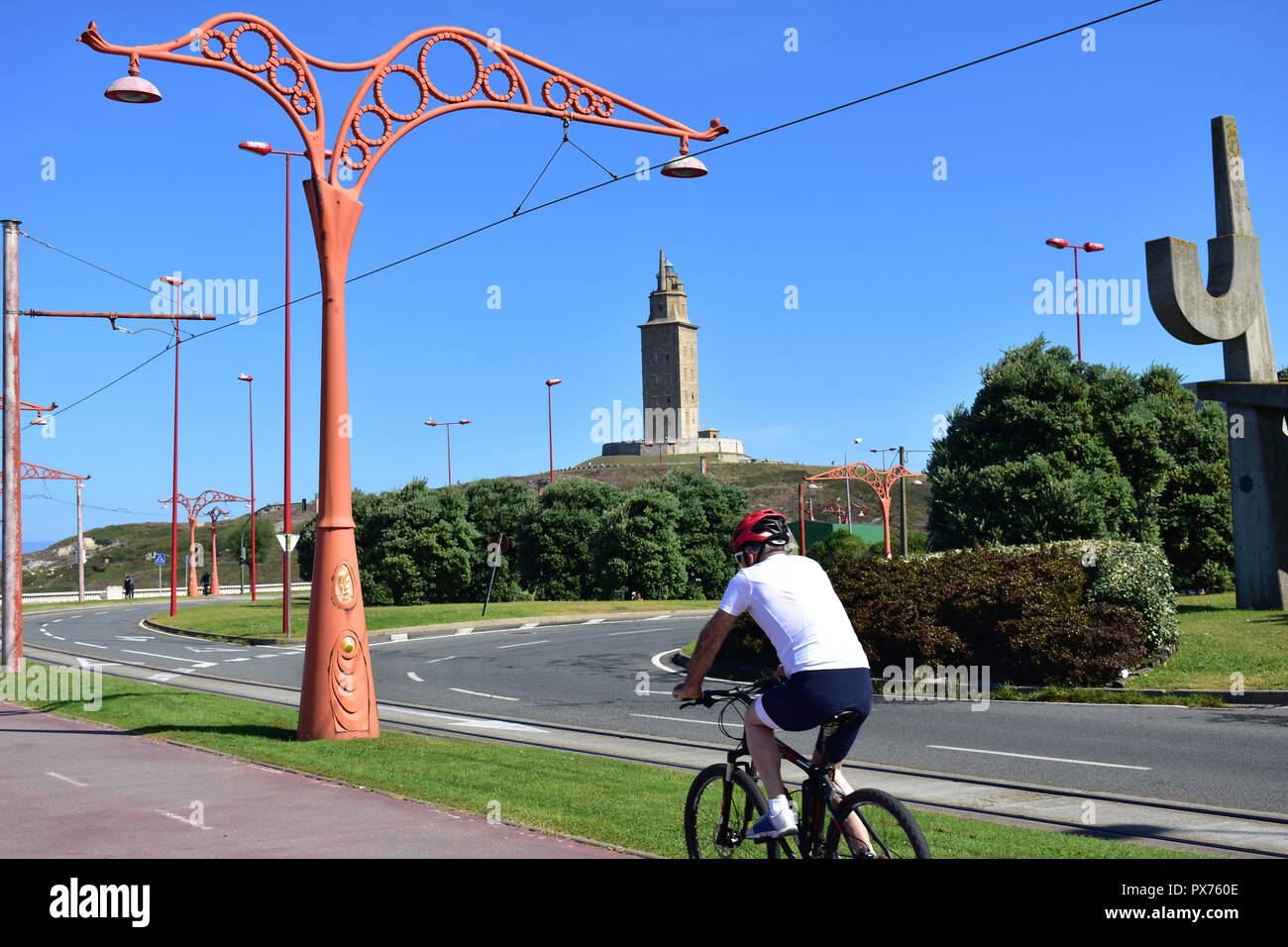 Man cycling in a promenade with trees, street lights, monuments and ...