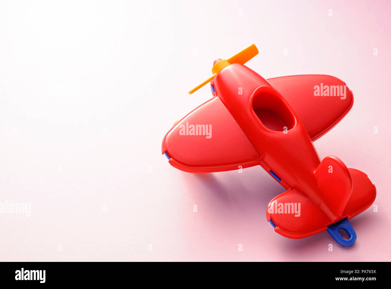 Children's toy red plane on a pink gradient background Stock Photo - Alamy