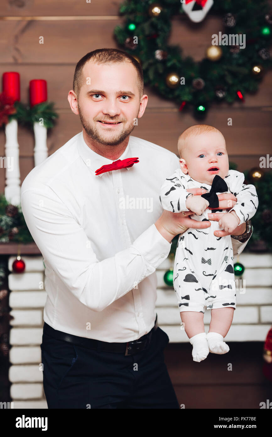 Handsome happy father in white shirt and tie holding little son by ...