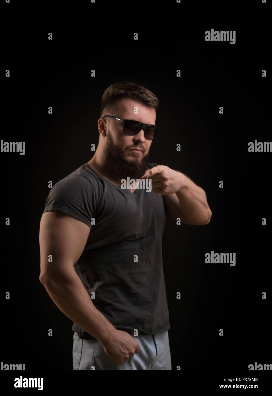 Bodybuilder in sunglasses portrait. Muscular man with a beard shows ...