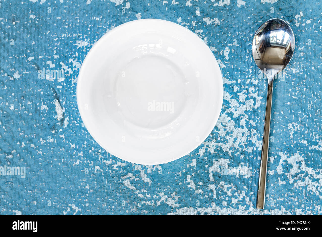 Crockery, empty plate, plate, spoon, stone background, blue boom Stock ...