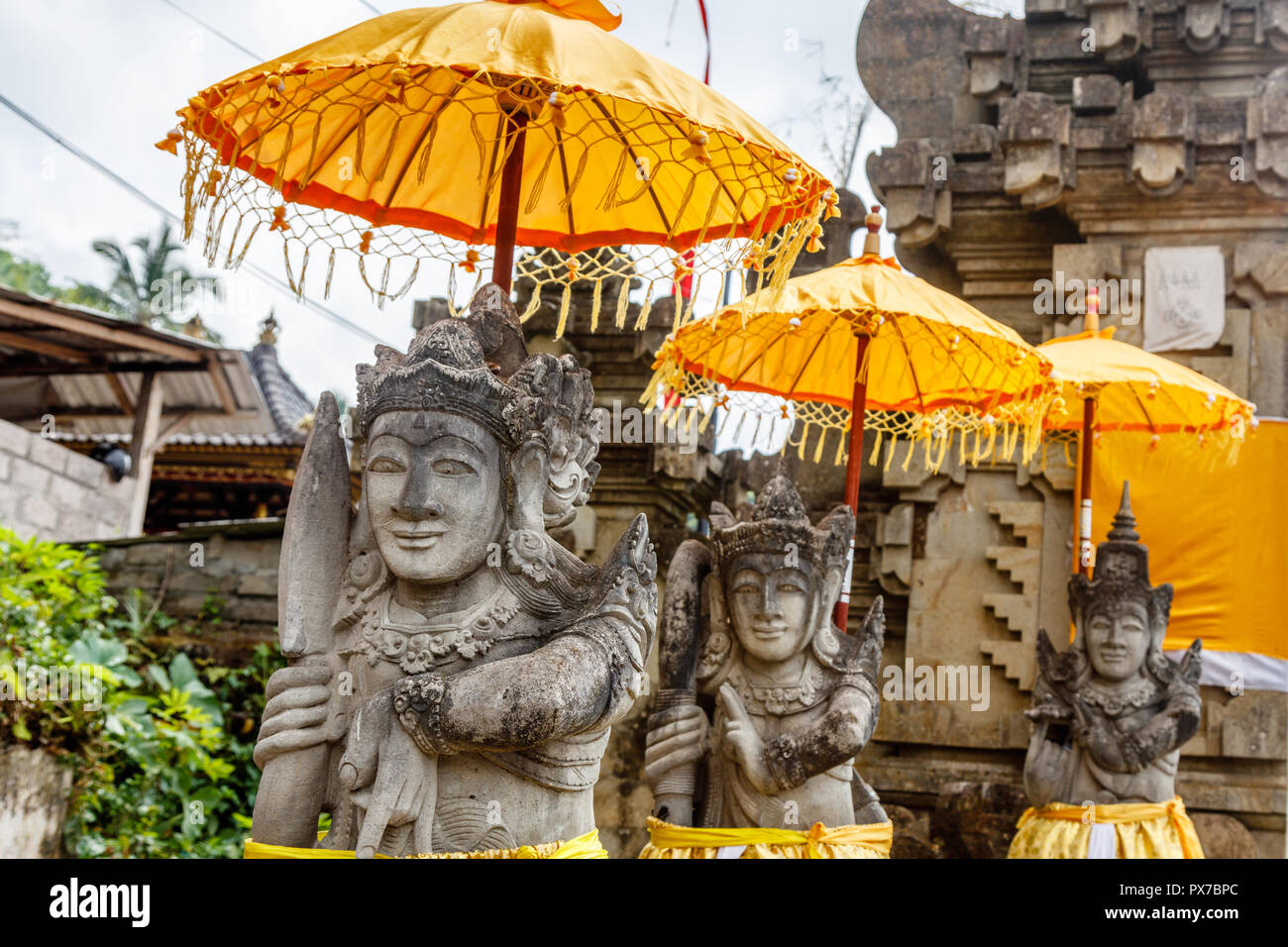 Entrance statues with yellow umbrellas at Pura Kehen, Balinese Hindu ...