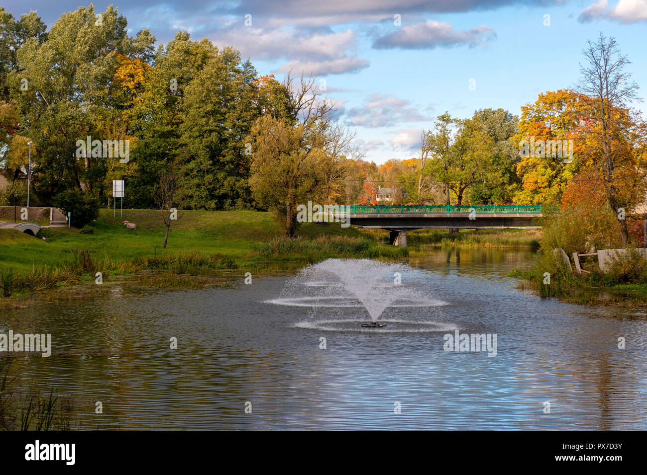 Dobele, Latvia. Autumn city landscape with river, bridge and fountains ...