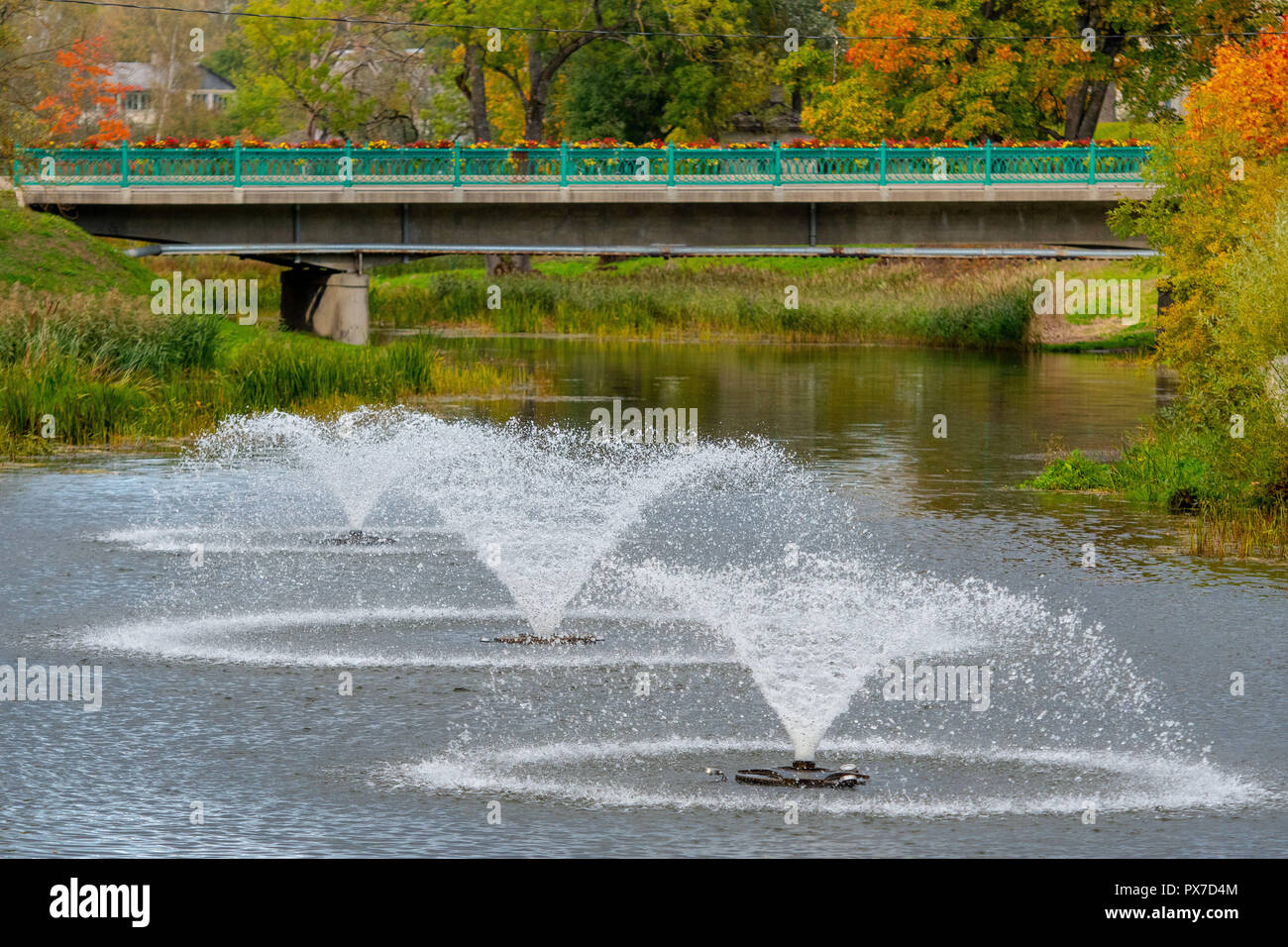 Dobele, Latvia. Autumn city landscape with river, bridge and fountains ...
