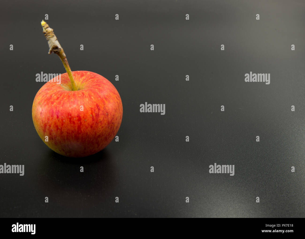 one single red apple on black background Stock Photo - Alamy