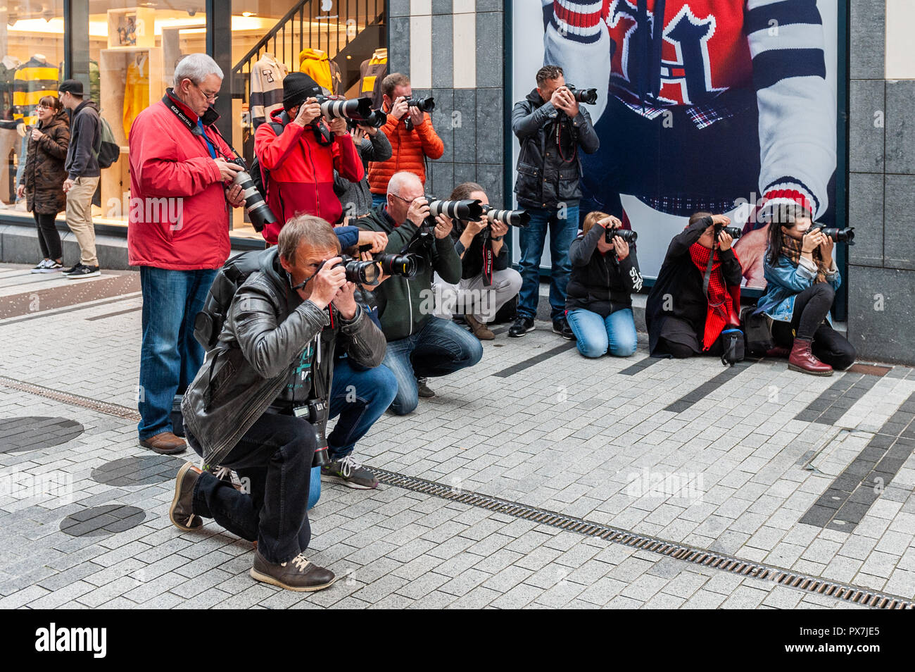 Group of photographers photograph a model during a lesson in Cork city ...