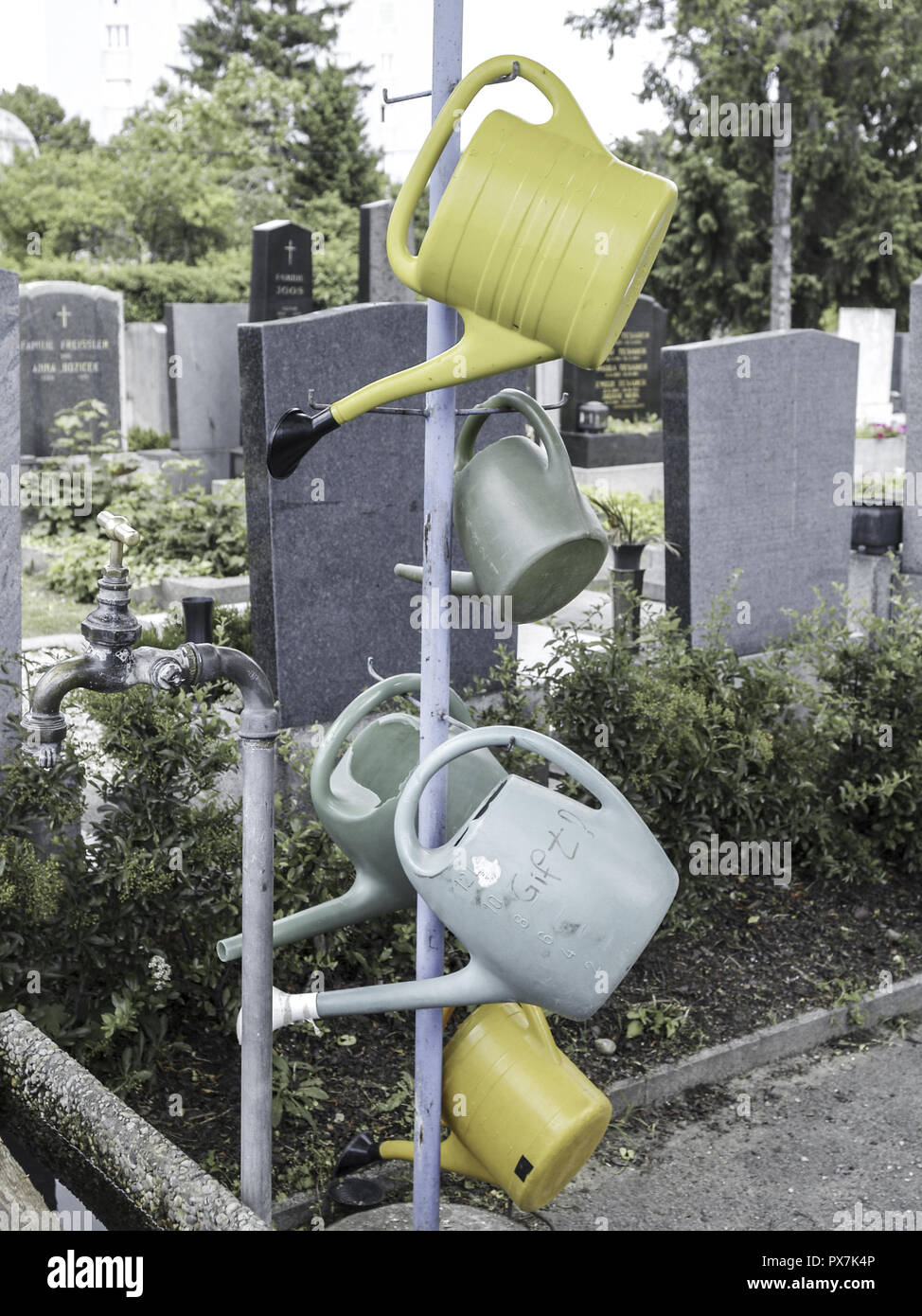 Watering cans at cemetery Stock Photo - Alamy