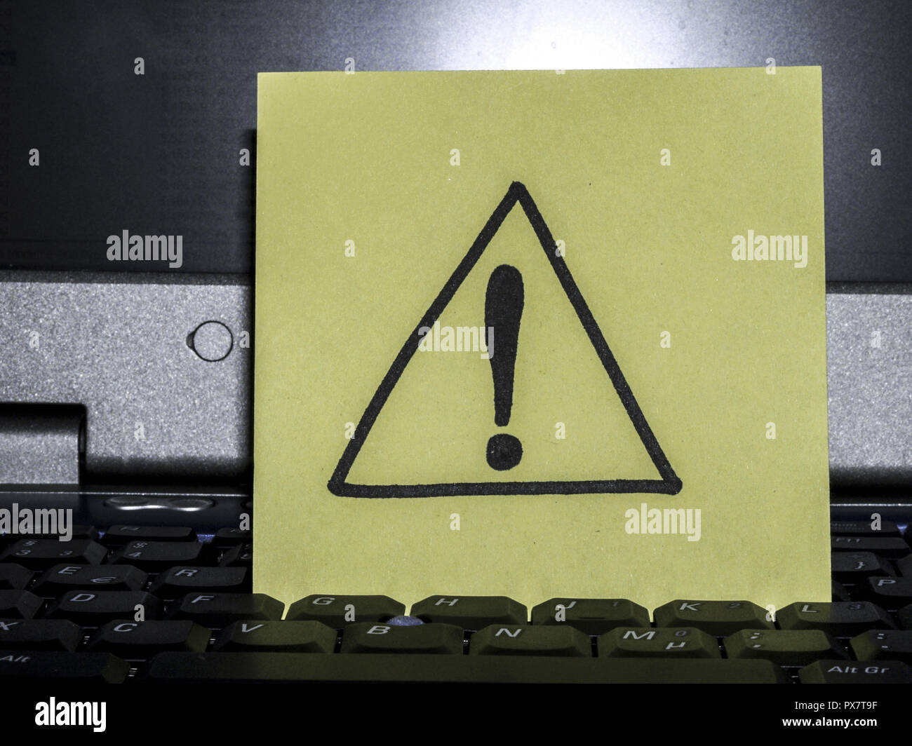 Memo note on notebook, danger exclamation mark in triangle drawing ...