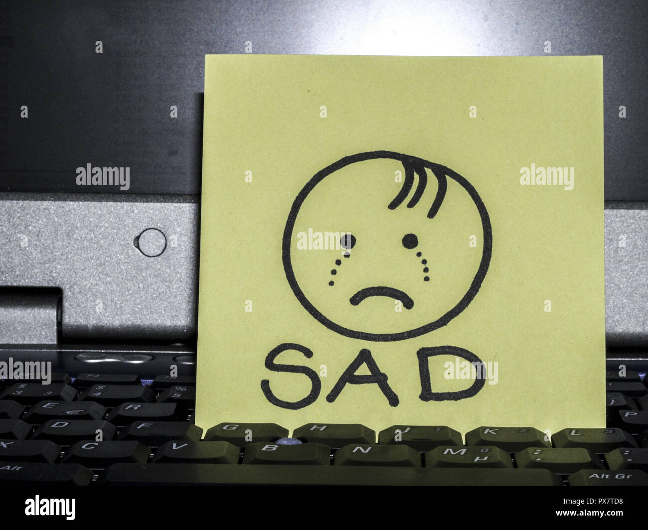 Memo note on notebook, drawing crying face sad Stock Photo - Alamy
