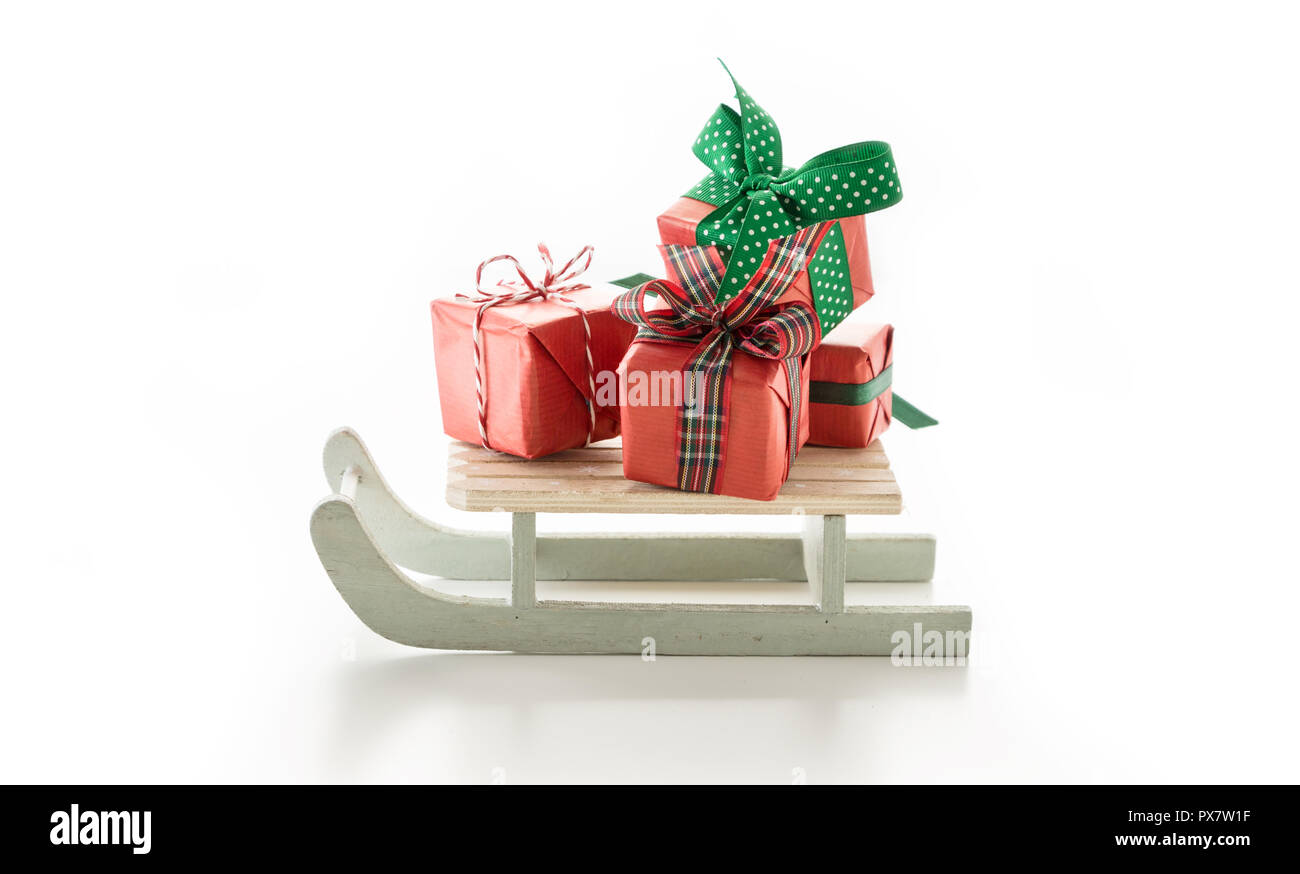 Wooden slide with present boxes decorated with seasonal ribbons, on ...