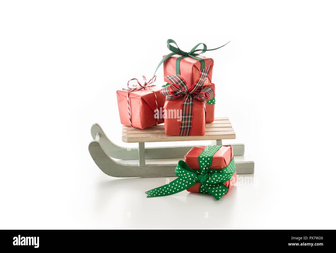 Wooden slide with present boxes decorated with seasonal ribbons, on ...