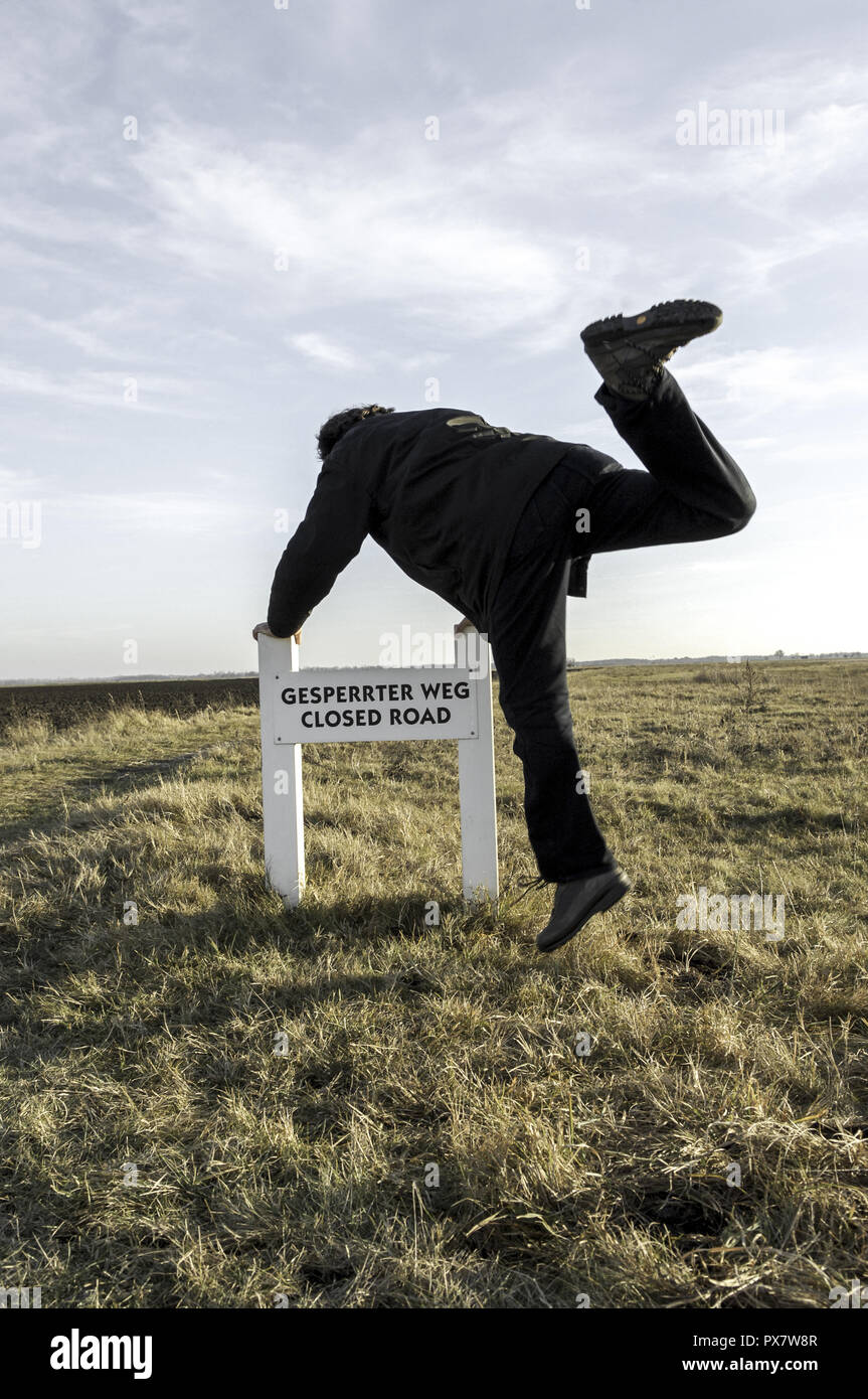 Man jumping over the sign closed road (model-released Stock Photo - Alamy