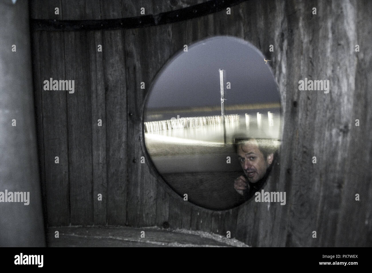 Man looking through a round openning (model-released Stock Photo - Alamy