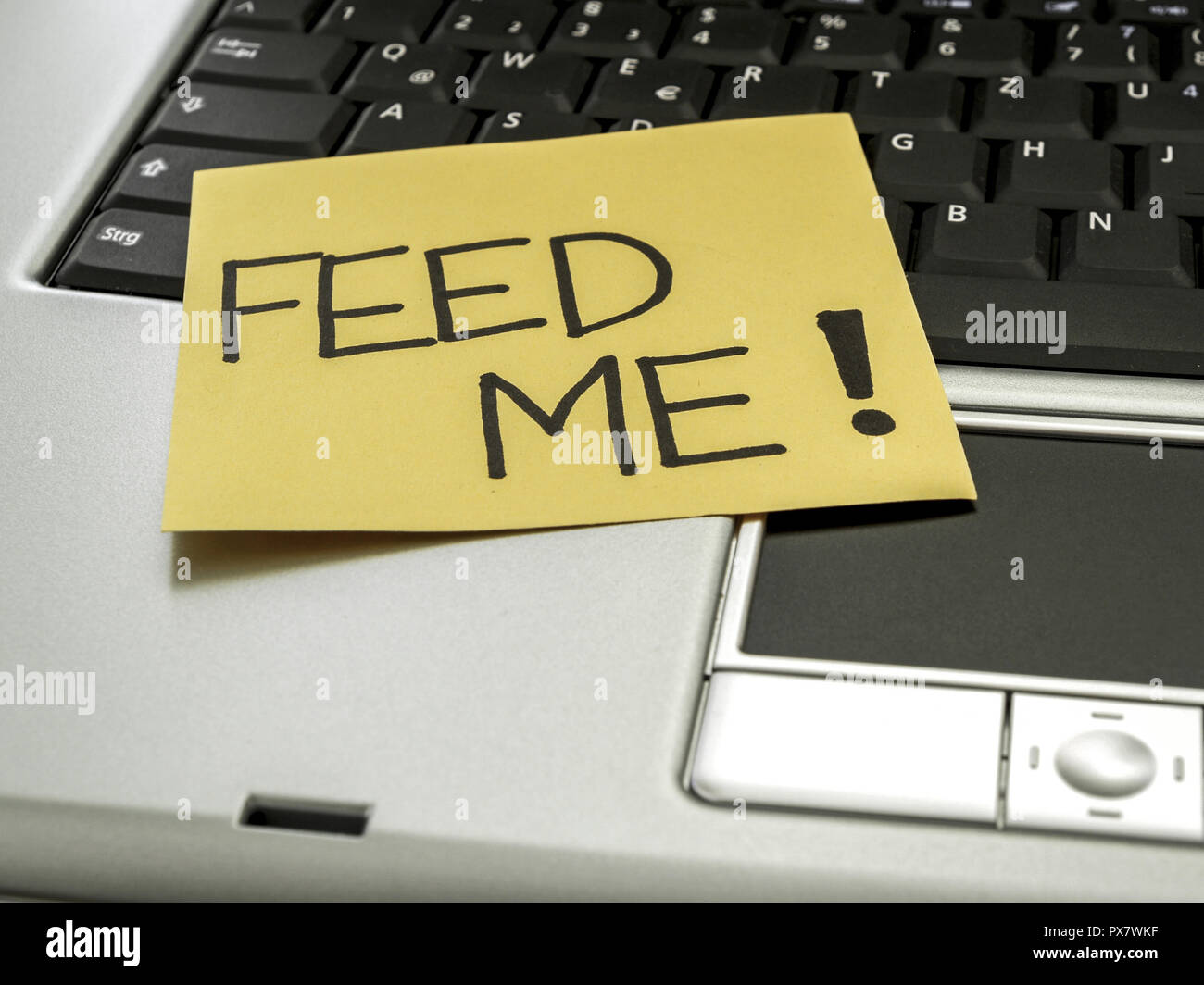 Memo note on notebook, feed me Stock Photo - Alamy