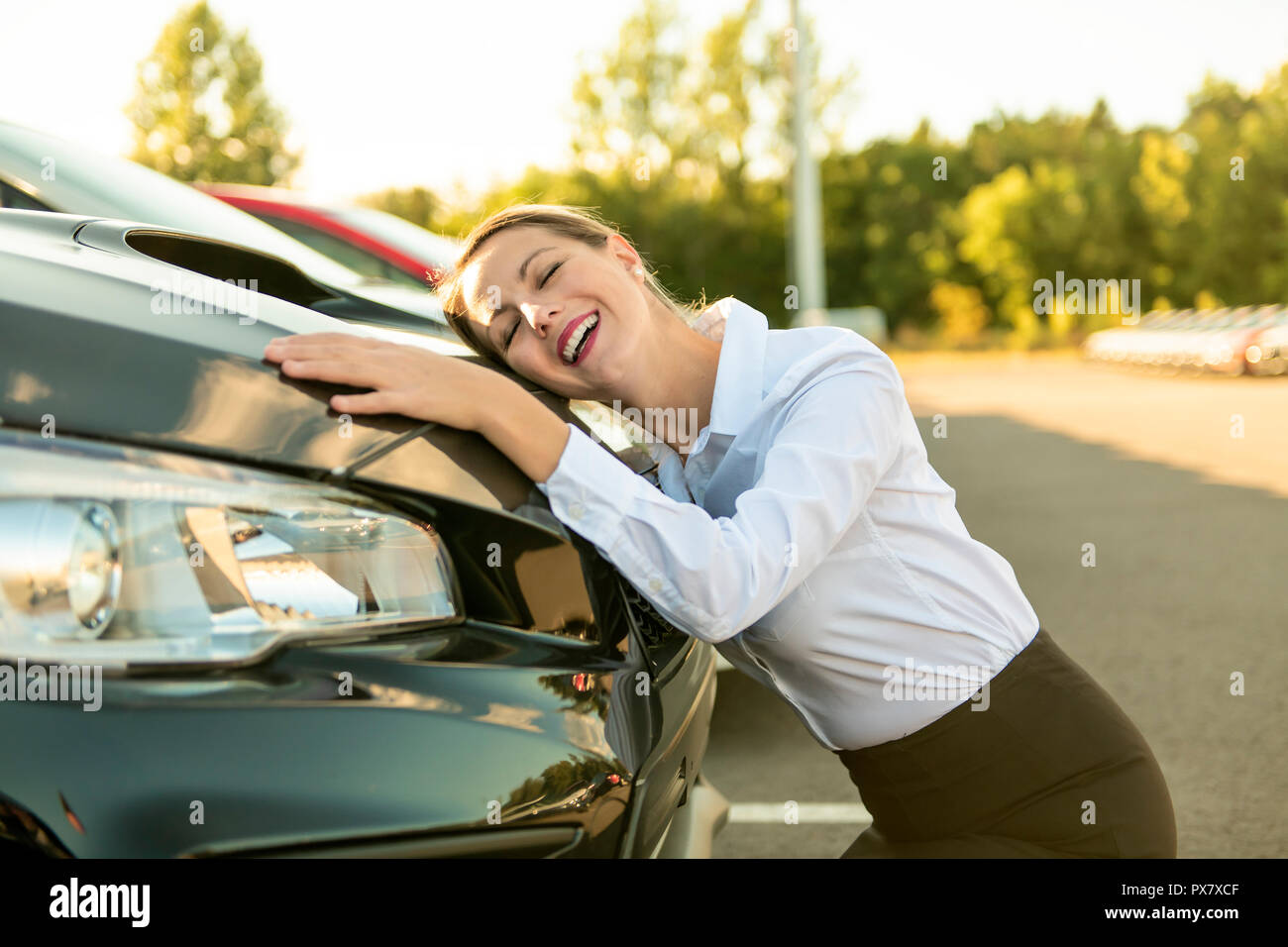 A Car seller woman hugging car at the garage Stock Photo - Alamy