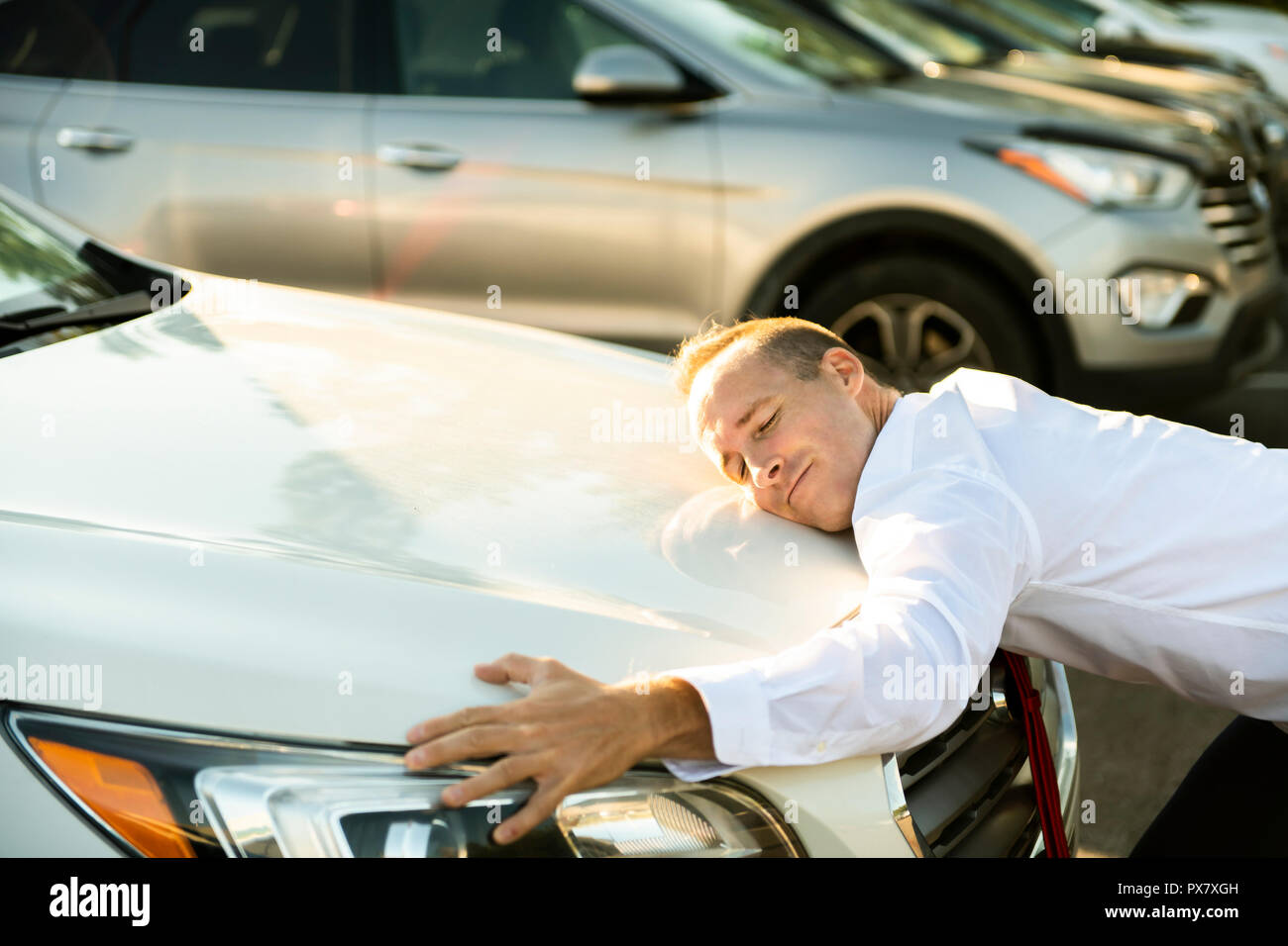 A Car seller man hugging car at the garage Stock Photo - Alamy