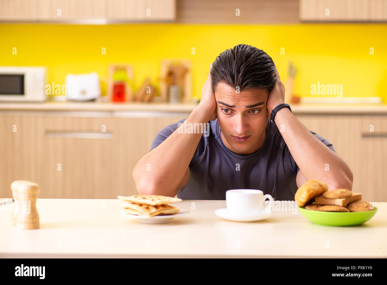 Young man in unhealthy food concept Stock Photo - Alamy