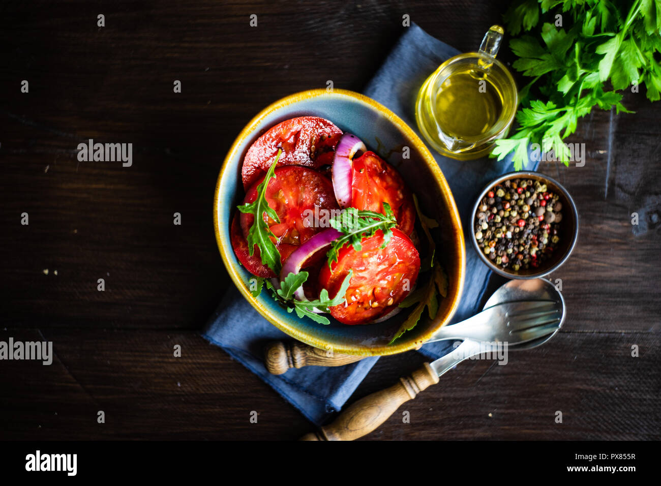 Ceramic bowl full of salad of organic vegetables like a tomato, red ...