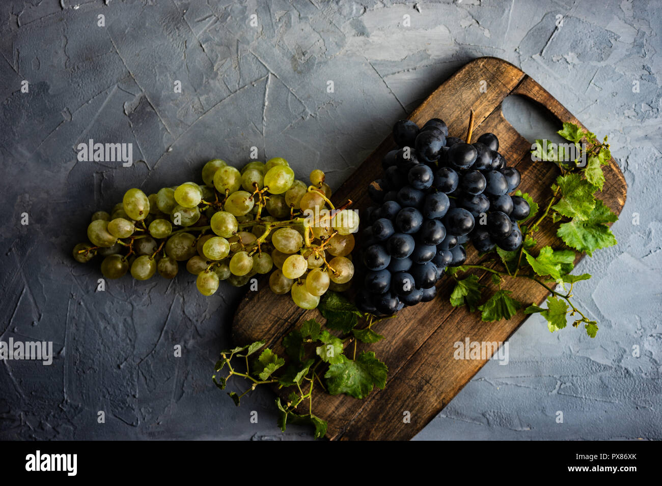 Red and green grape variation og grey concrete background with copy ...