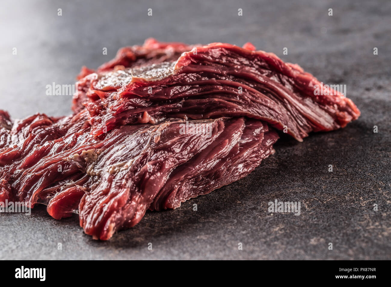 Portion of raw beef meat on dark butcher board Stock Photo - Alamy