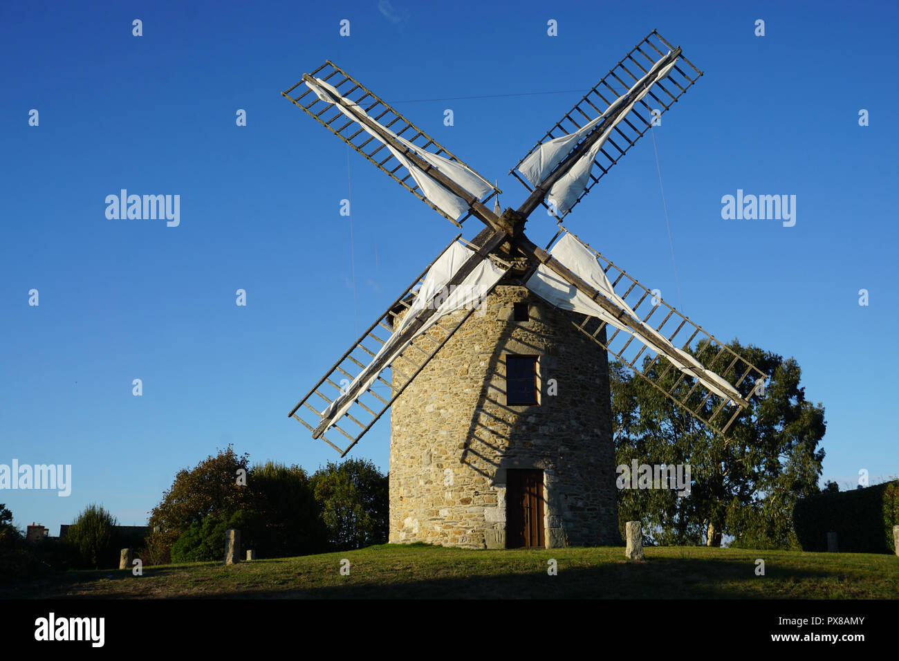Old stone windmill with wood wings in the park in brittany, France at ...