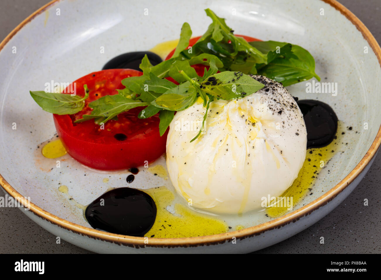 Buratta cheese with herbs and tomato Stock Photo - Alamy