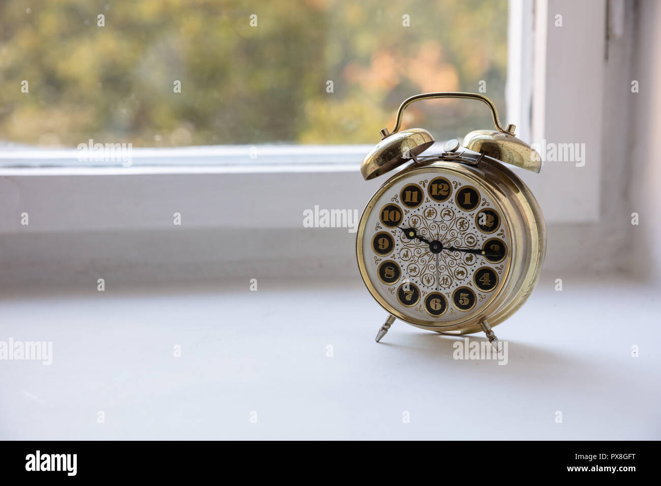 Time management. Golden alarm clock in the morning, blur glass window ...