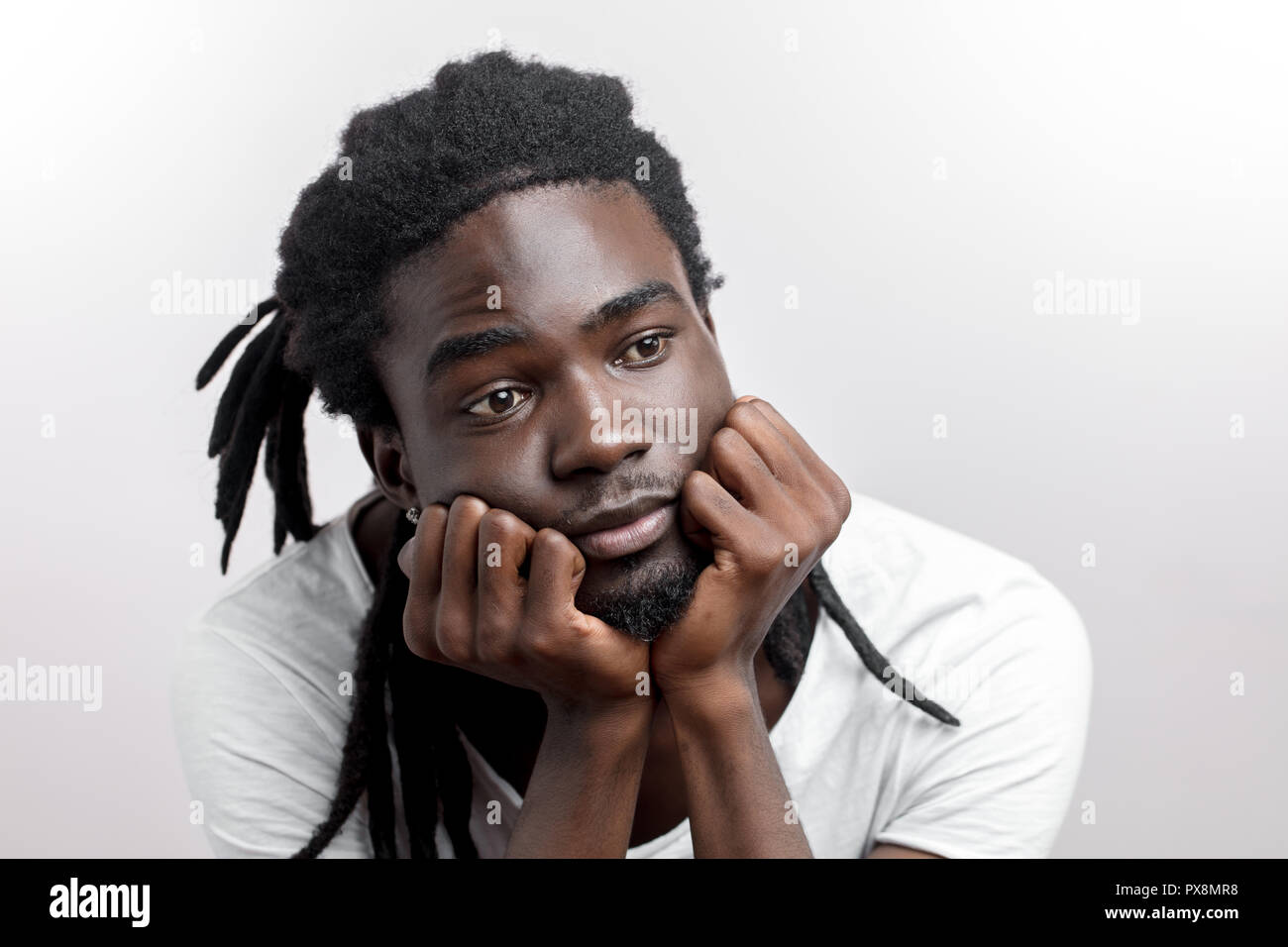 Thinking or dreaming african man with dreadlocks on white background ...