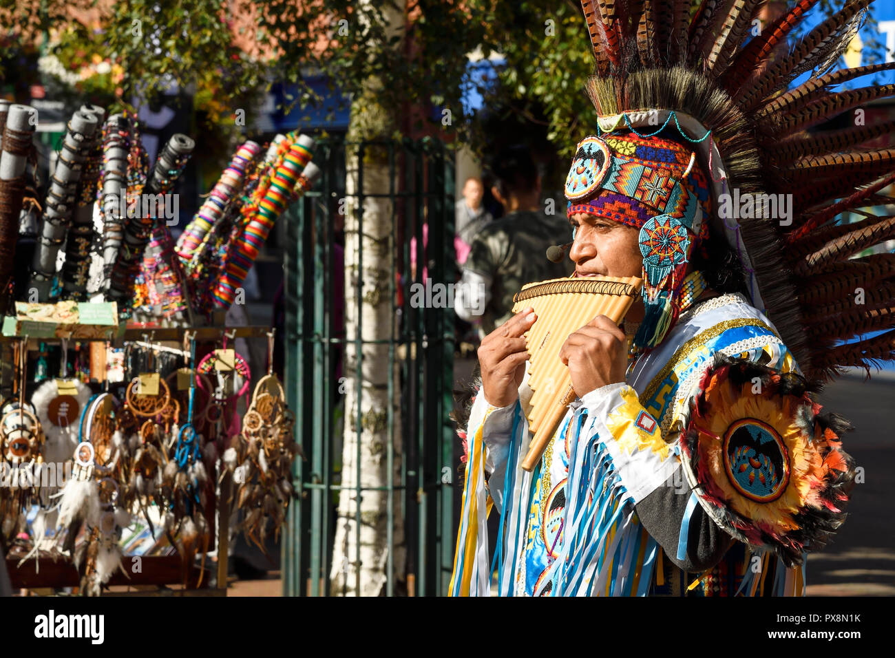 A busker in traditional costume playing panpipes in Crewe town centre ...