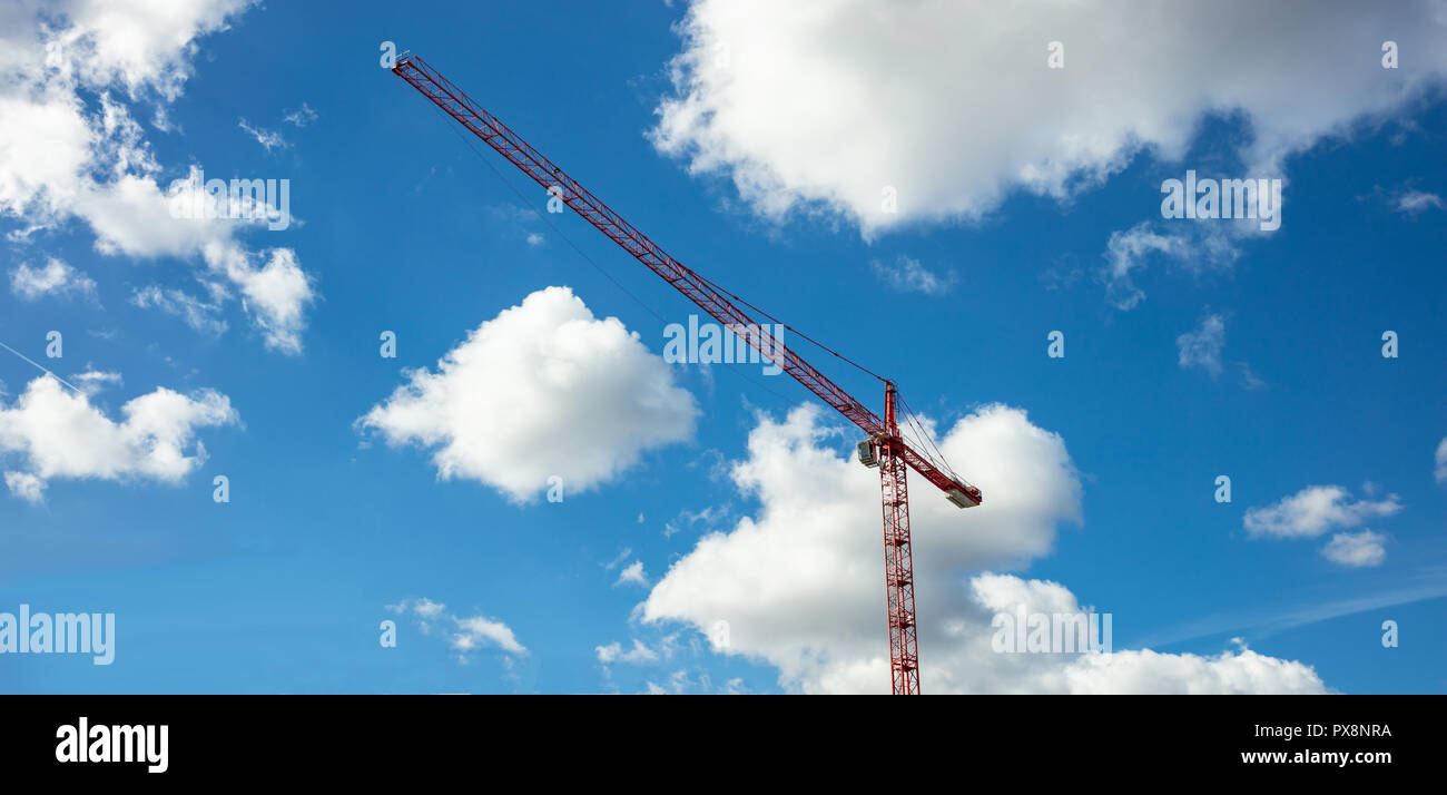 Under construction. Red tower crane on blue sky background Stock Photo ...