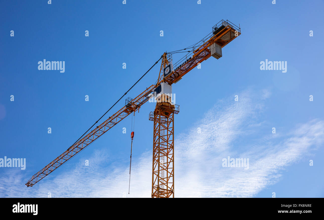 Under construction. Red tower crane on blue sky background Stock Photo ...