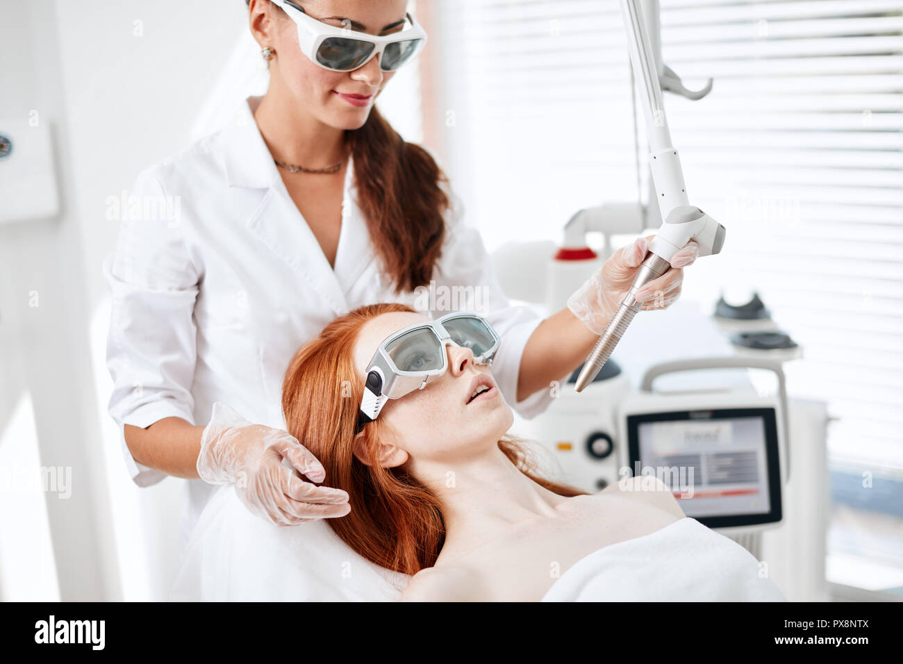 Woman getting laser face treatment in medical center, skin rejuvenation ...