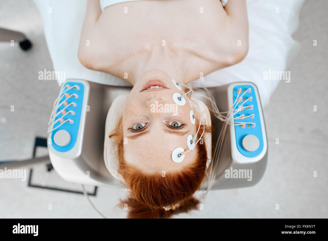 Woman with electrodes on her face, receiving electric stimulation on ...
