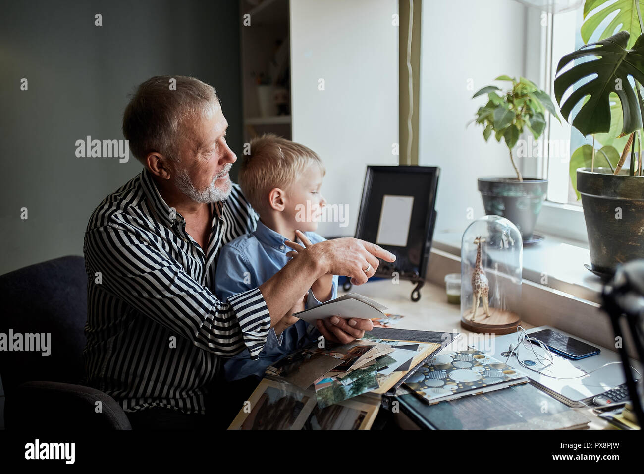 Grandfather and grandson on sofa at home. Grandpa and children watching ...