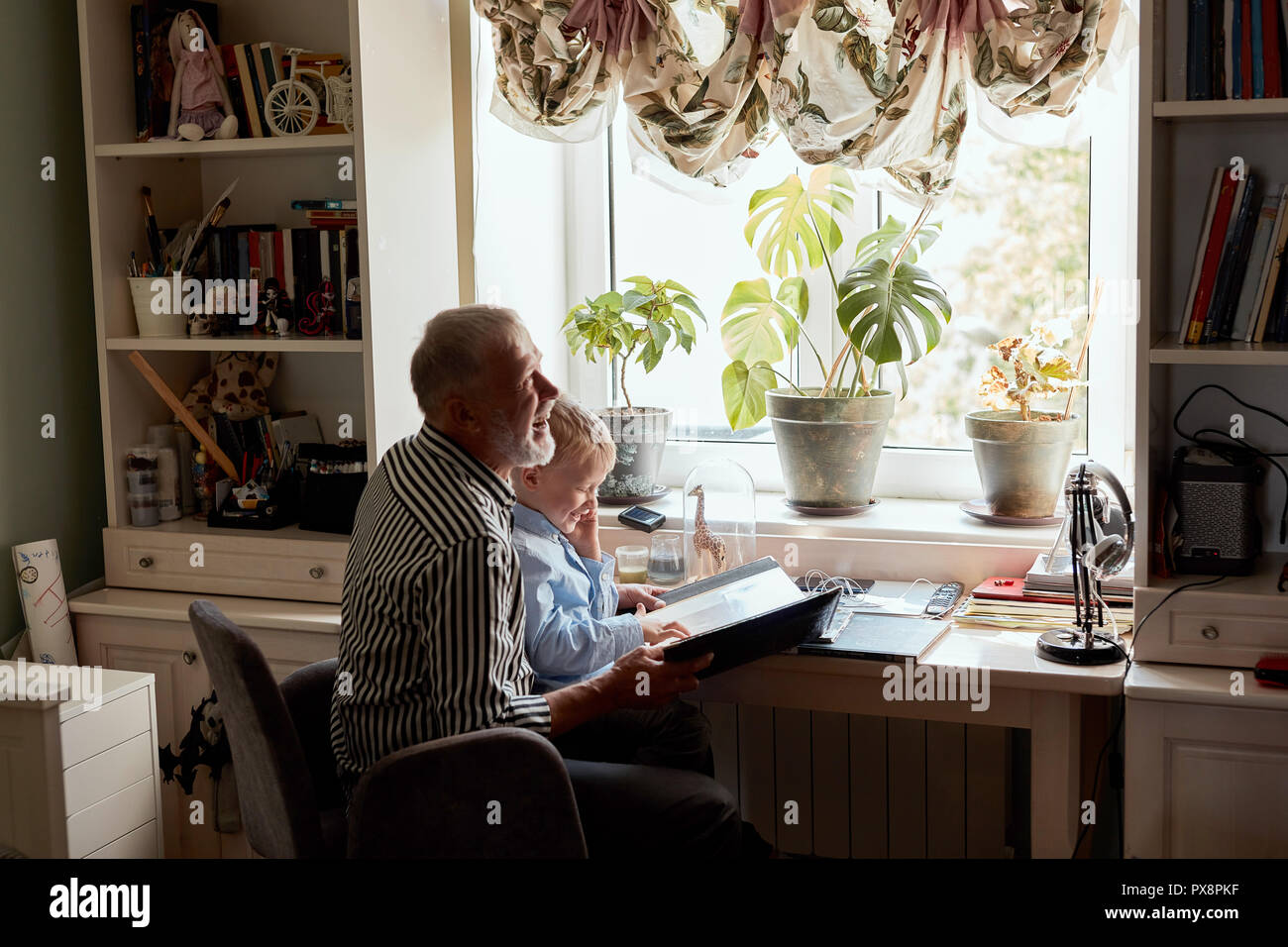 Grandfather and grandson on sofa at home. Grandpa and children watching ...