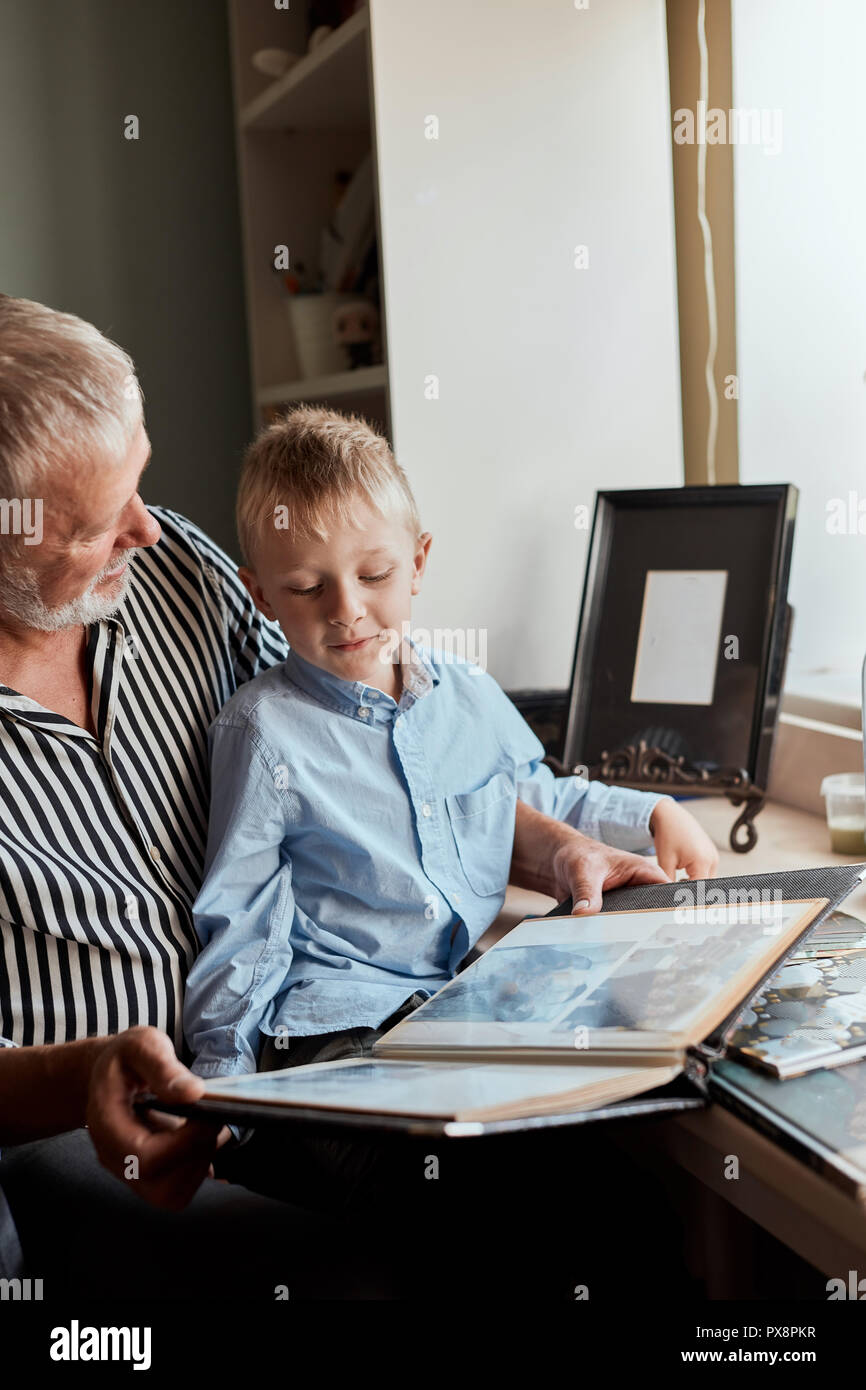 Grandfather and grandson on sofa at home. Grandpa and children watching ...