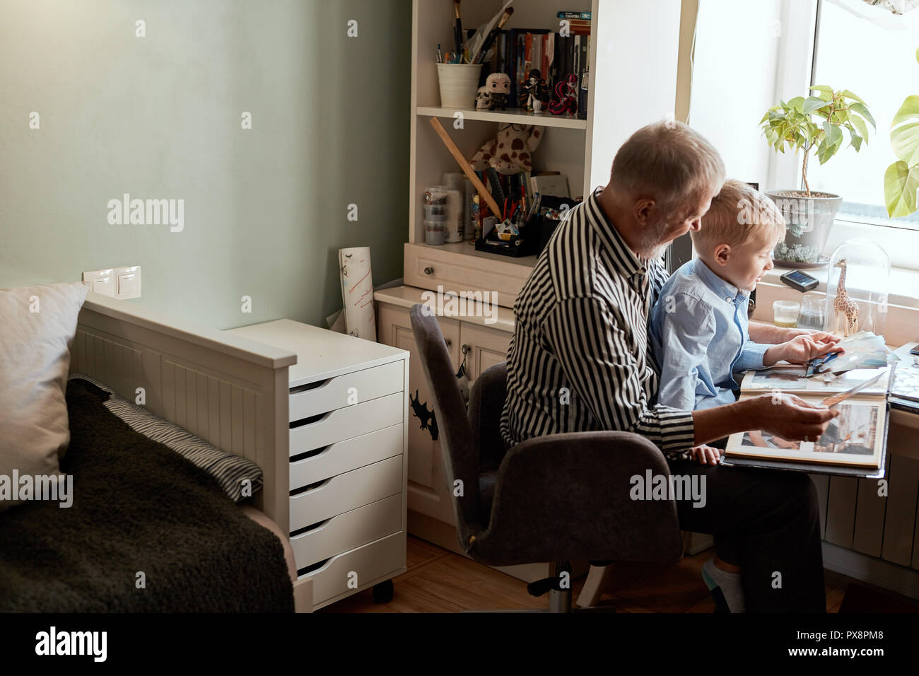 Grandfather and grandson on sofa at home. Grandpa and children watching ...
