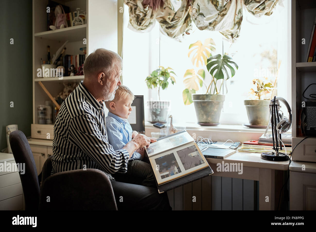 Grandfather and grandson on sofa at home. Grandpa and children watching ...