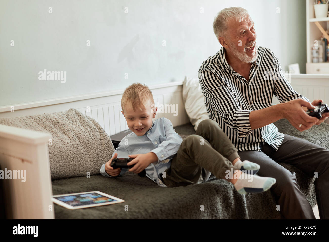 Grandfather and grandson playing video games on computer with joystick ...