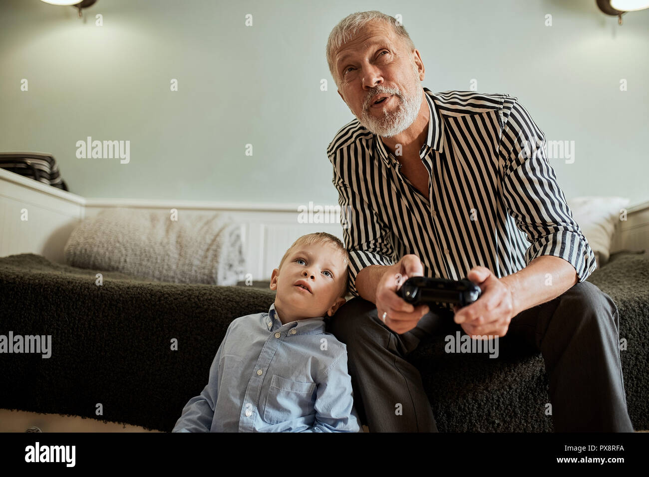 Grandfather and grandson playing video games on computer with joystick ...