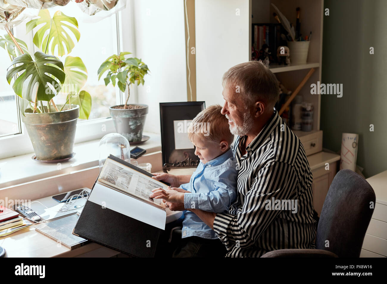 Grandfather and grandson on sofa at home. Grandpa and children watching ...