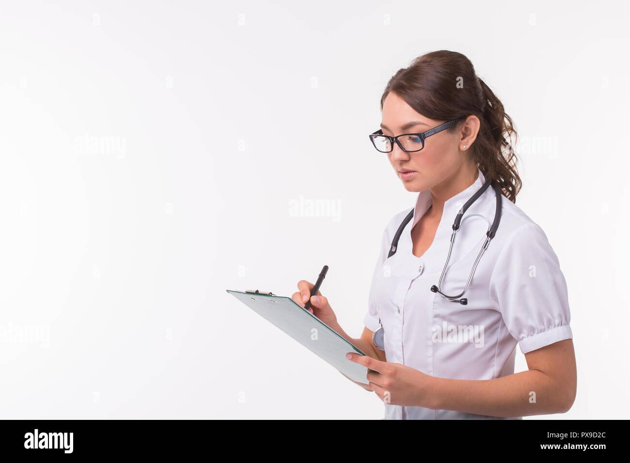 Female medicine doctor hand holding pen writing something on clipboard ...