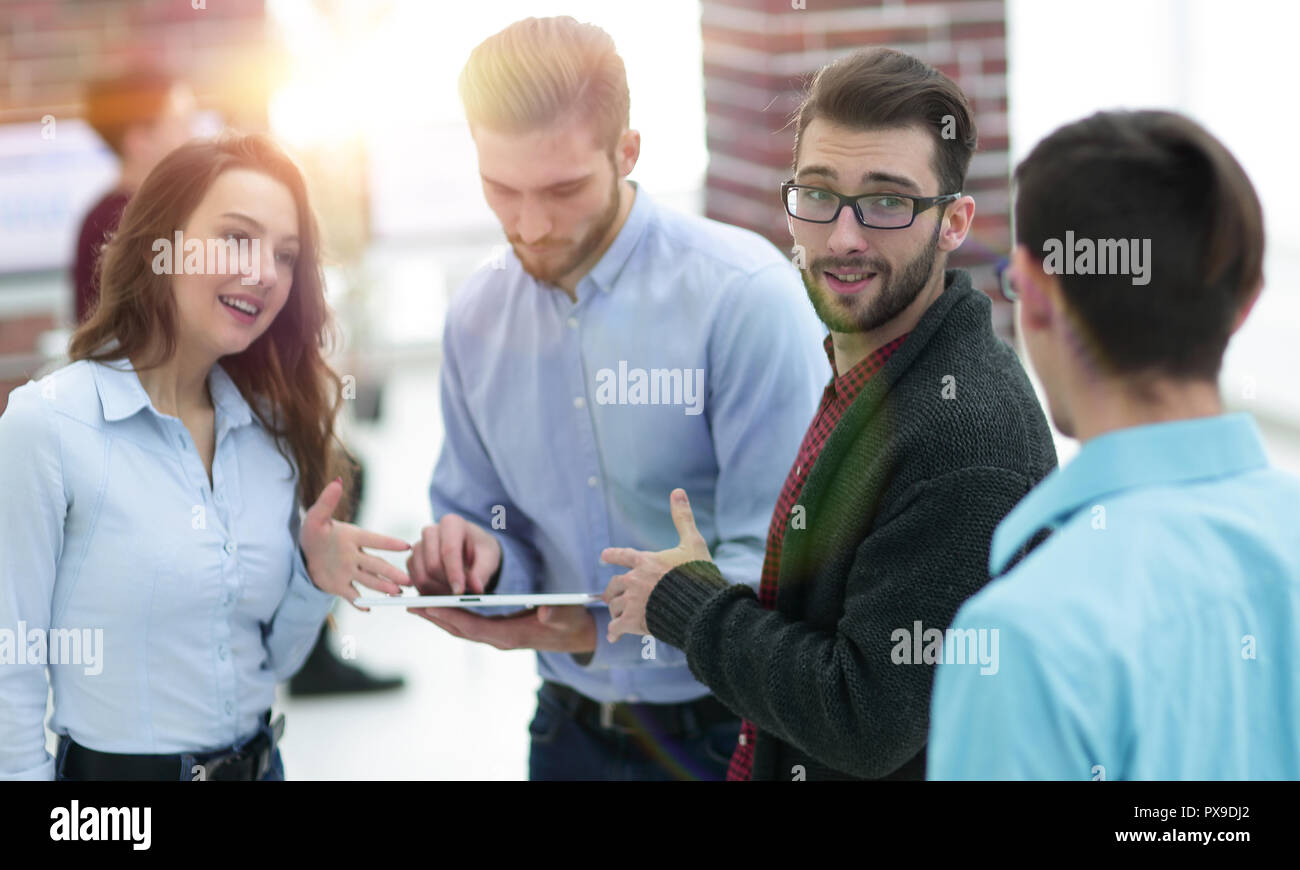 Beautiful business people are using gadget, talking and smiling while ...