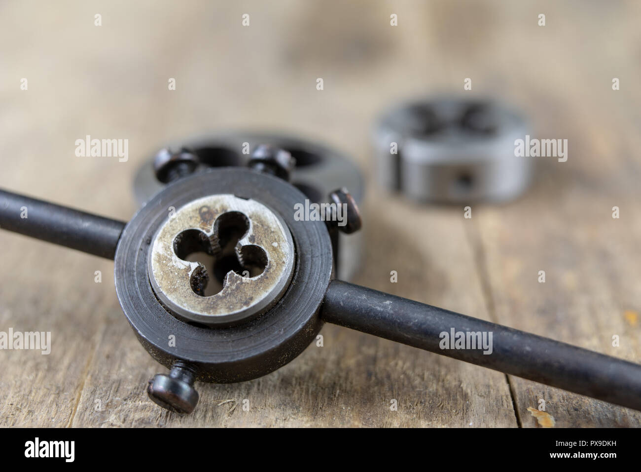 Metalwork tools on the workshop table. Threading dies and taps in an ...