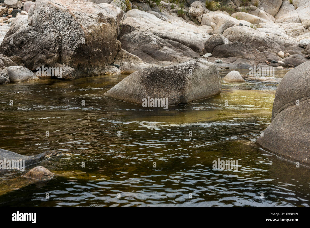 approach or close-up of a river in which reflections of the sunny sky ...