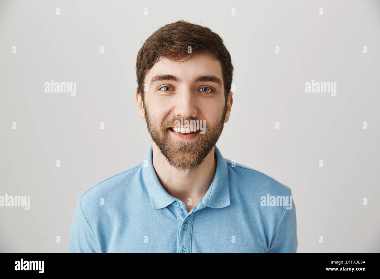 Waist Up Shot Of Funny Emotive Adult Bearded Guy In Blue Polo Shirt